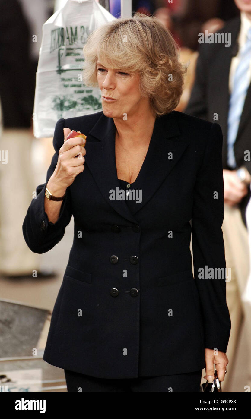 The Duchess Of Cornwall bites into an apple at the Farmer's Market in ...
