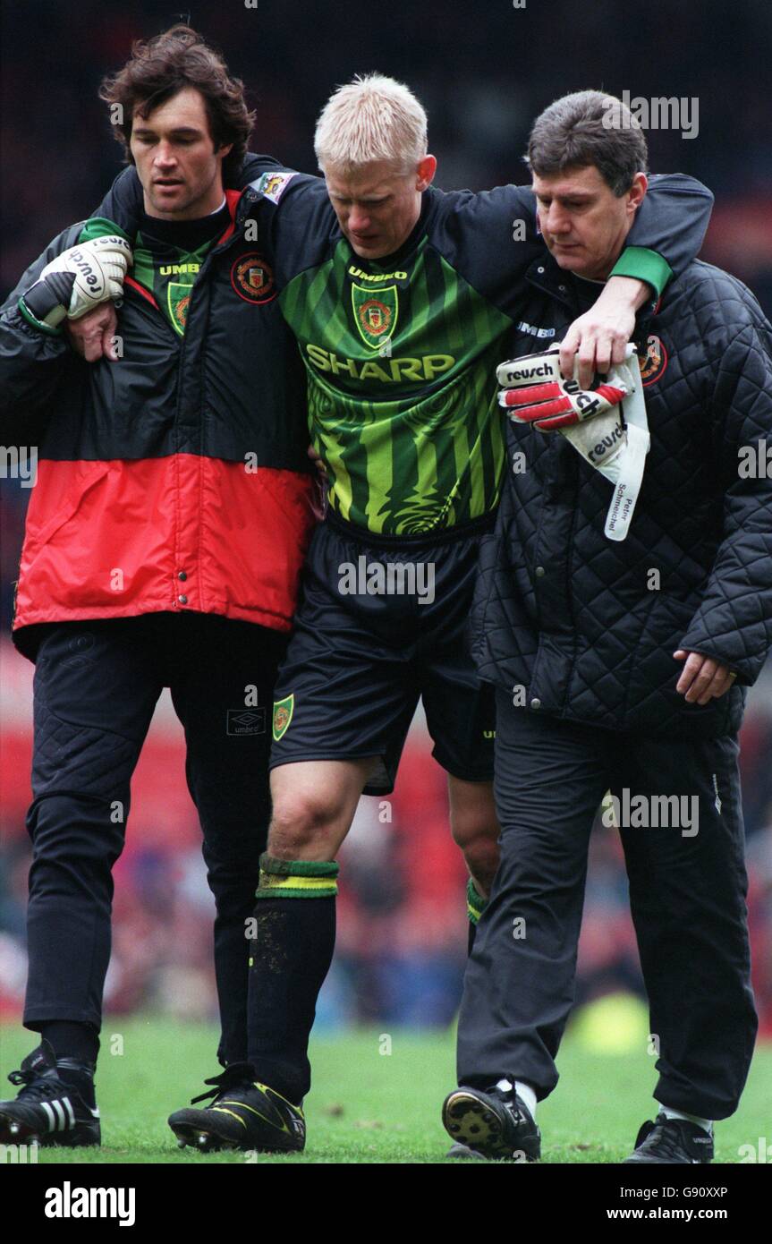 L-R; Raimond Van Der Gouw, Manchester United helps to carry Peter ...