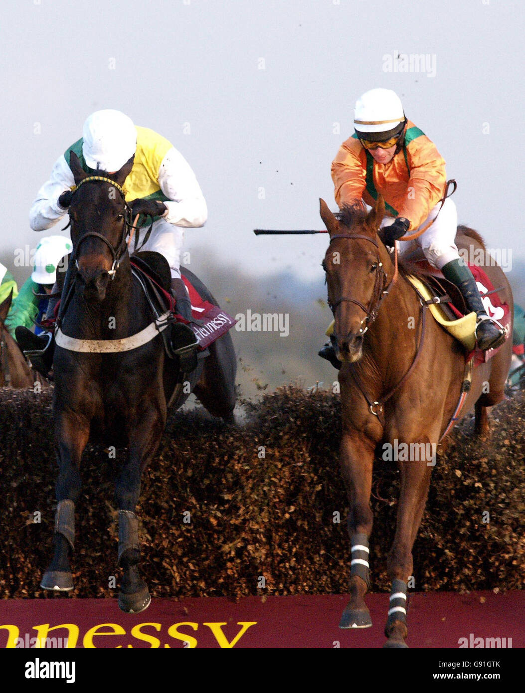 Trabolgan and jockey Mick Fitzgerald (L) jumps the last with L'Ami and ...