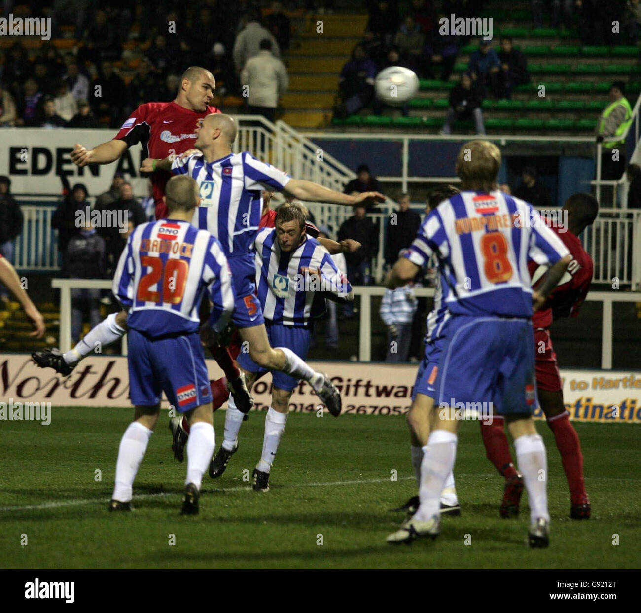 Tamworth's Matt Redmille (left in red) jumps above the Hartlepool ...