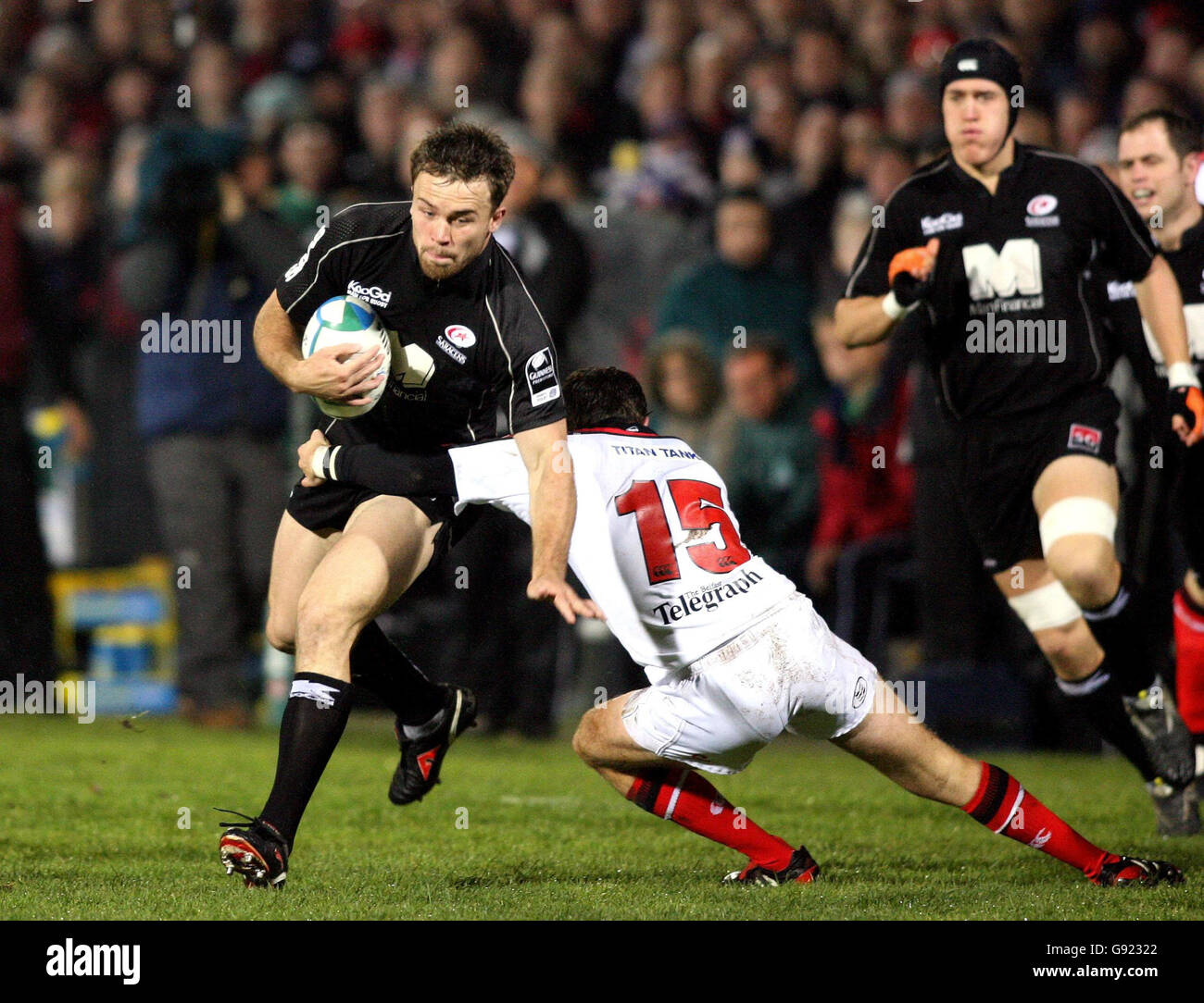 Saracens' Ben Russell (L) is stopped by Ulster's Bryn Cunningham during ...
