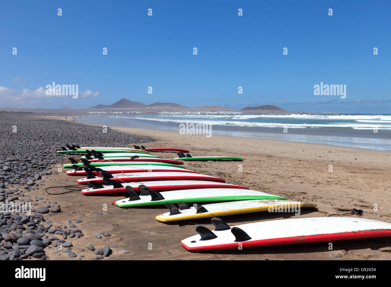 Surf boards lined up on the beach Playa de Famara lanzarote Stock Photo ...