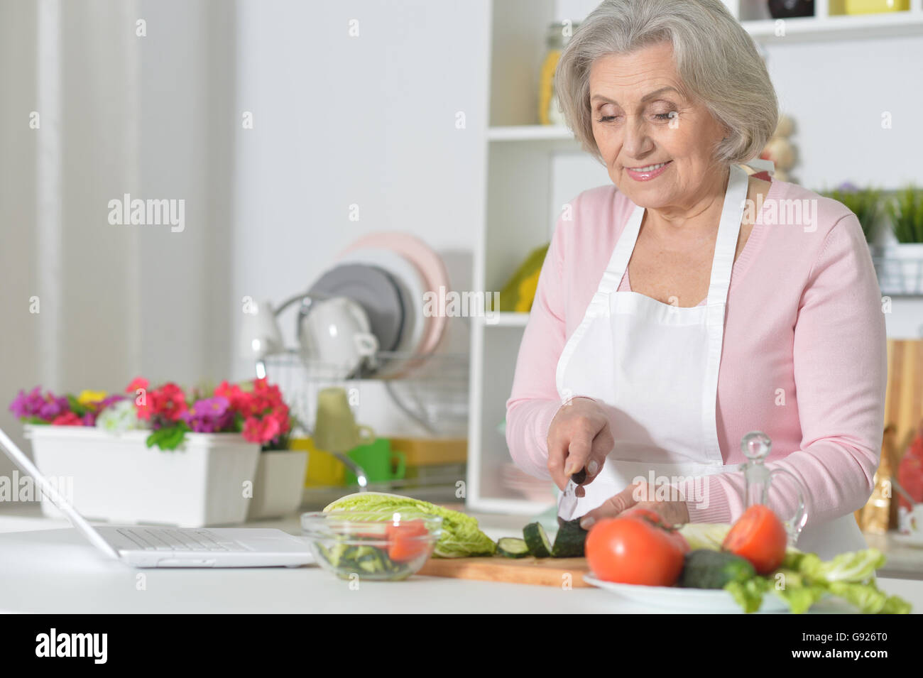 Senior woman cooking in kitchen Stock Photo - Alamy
