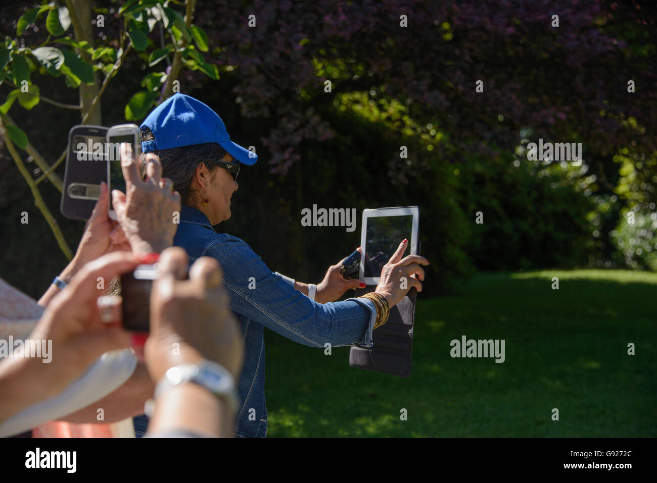 Taking picture with a ipad, phone compact camera in a group Stock Photo ...