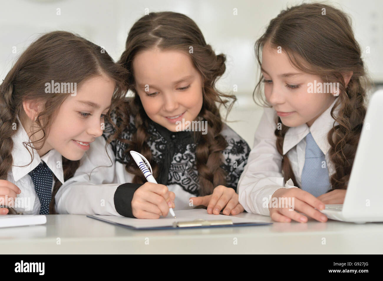 Three little girls making homework Stock Photo - Alamy