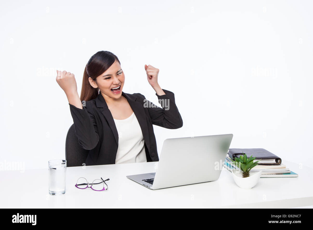 Business woman cheering in front of computer Stock Photo - Alamy