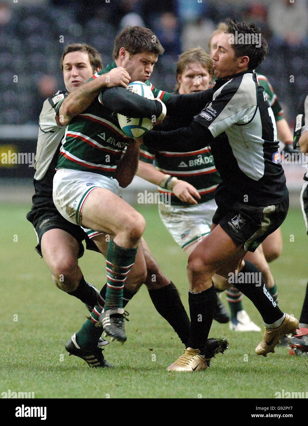Leicester Tigers' Danny Hipkiss (C) tangles with Osprey's Jason Spice ...