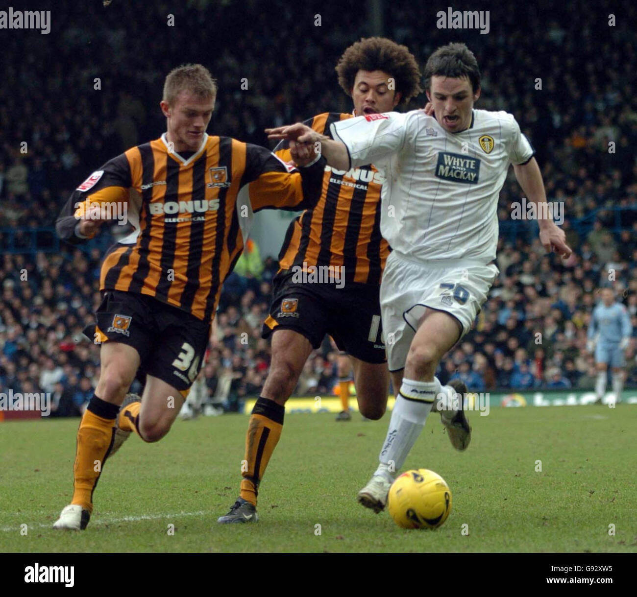 Leeds' Jonathan Douglas (R) drives the ball away from Hull's Scott ...