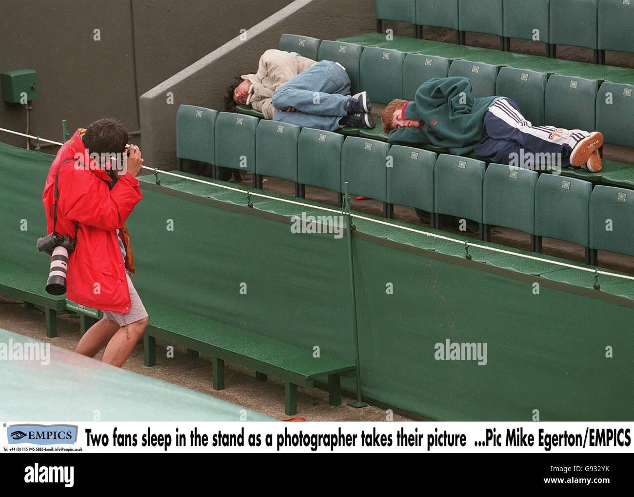 Two fans sleep in the stand as a photographer takes their picture Stock ...
