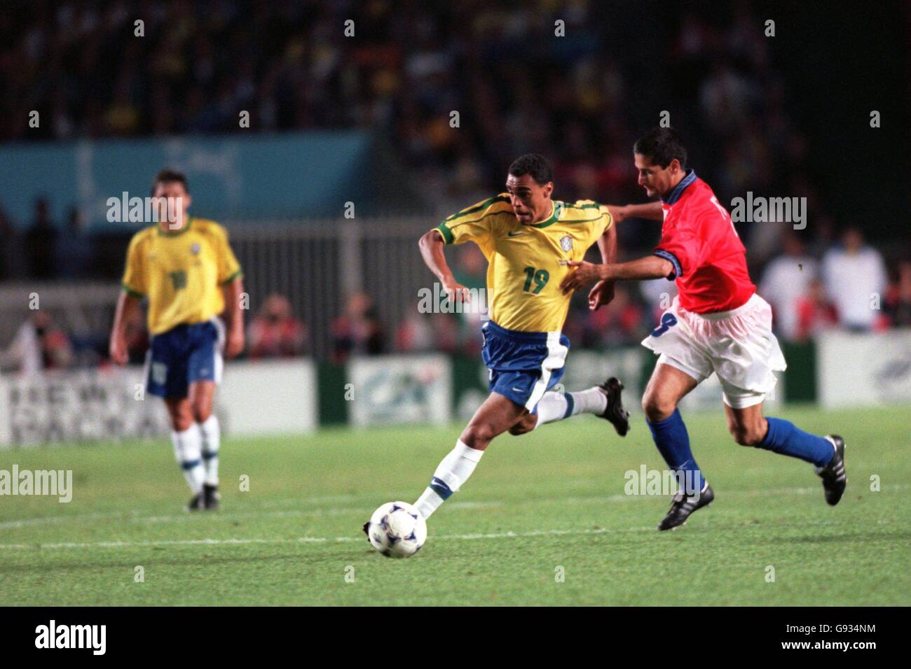 Denilson of Brazil (centre) tries to accelerate away from Chile's ...