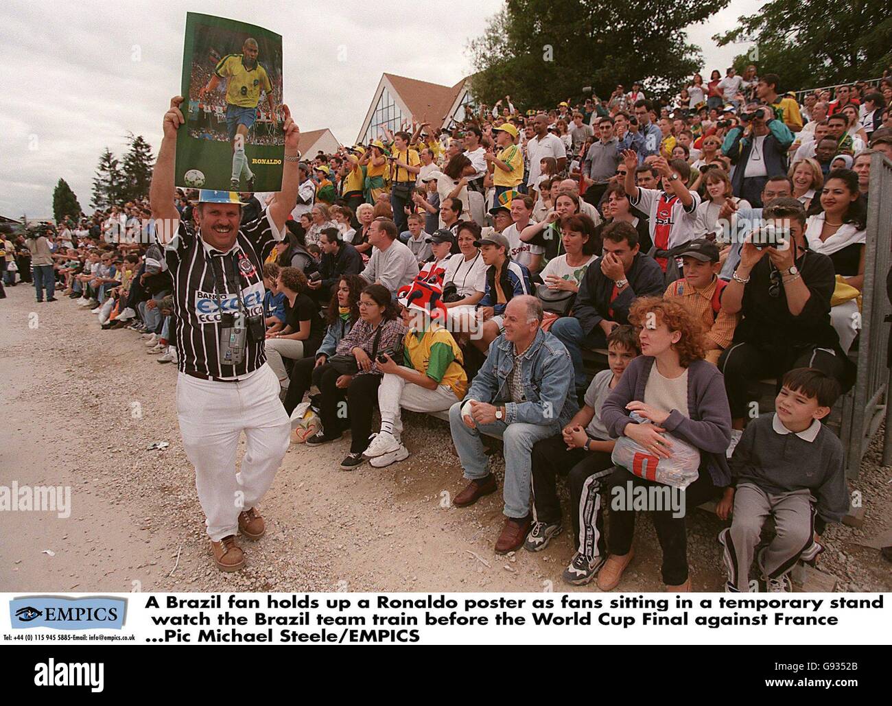 A Brazil fan holds up a Ronaldo poster as fans sitting in a temporary ...