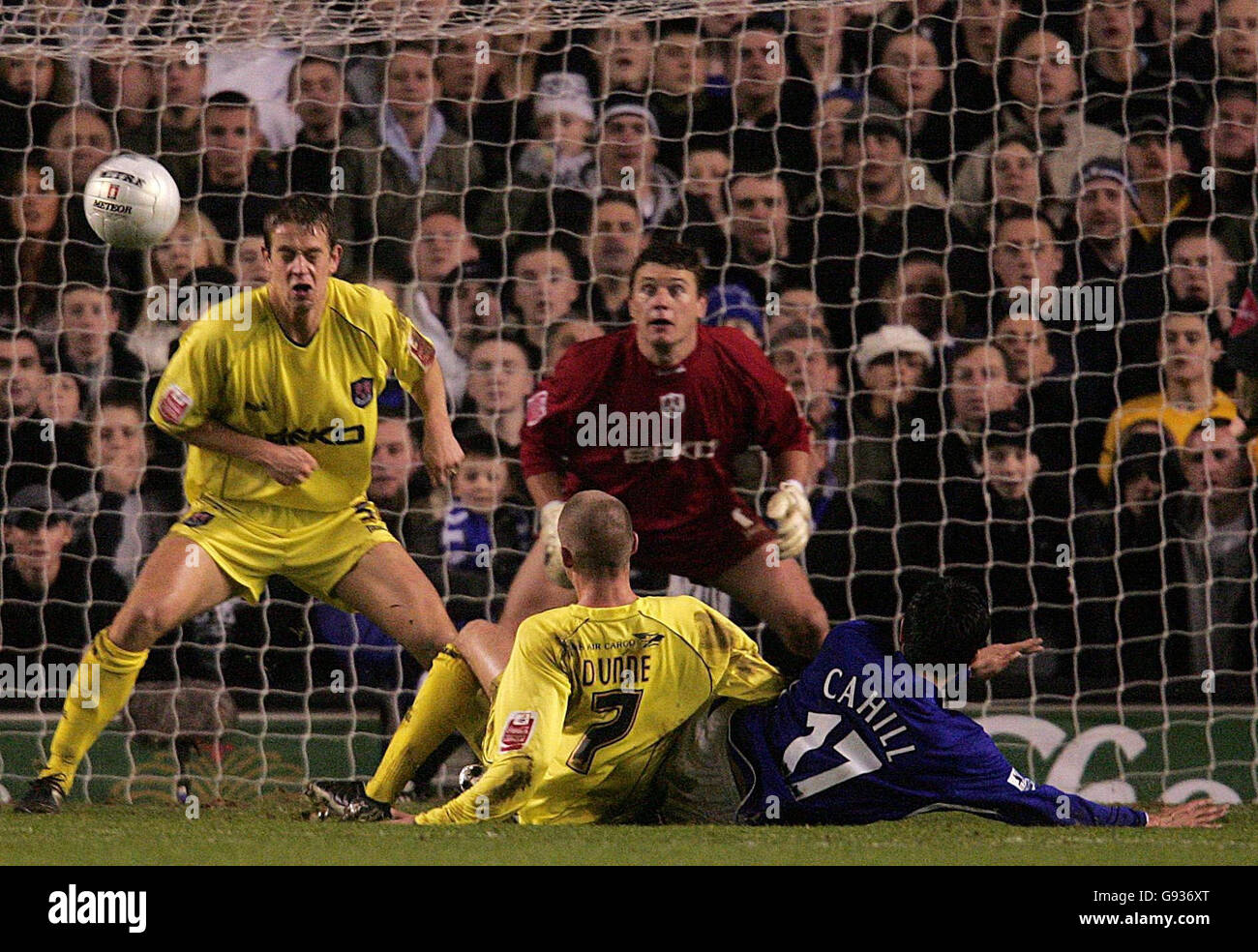 Everton's Tim Cahill (R) slides to score past Millwall's Alan Dunne ...