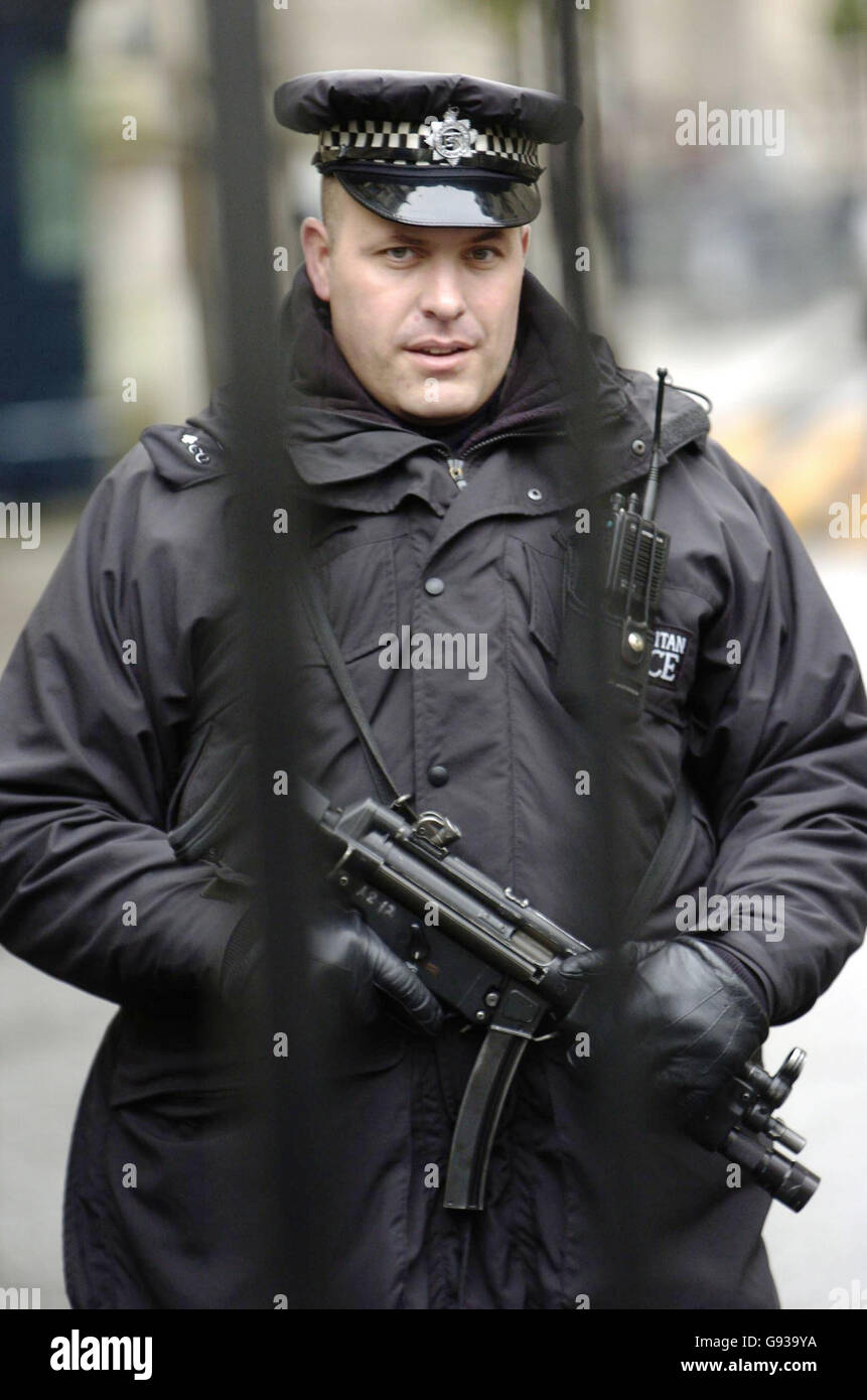 An armed police officer stands behind the gates of Downing Street in ...