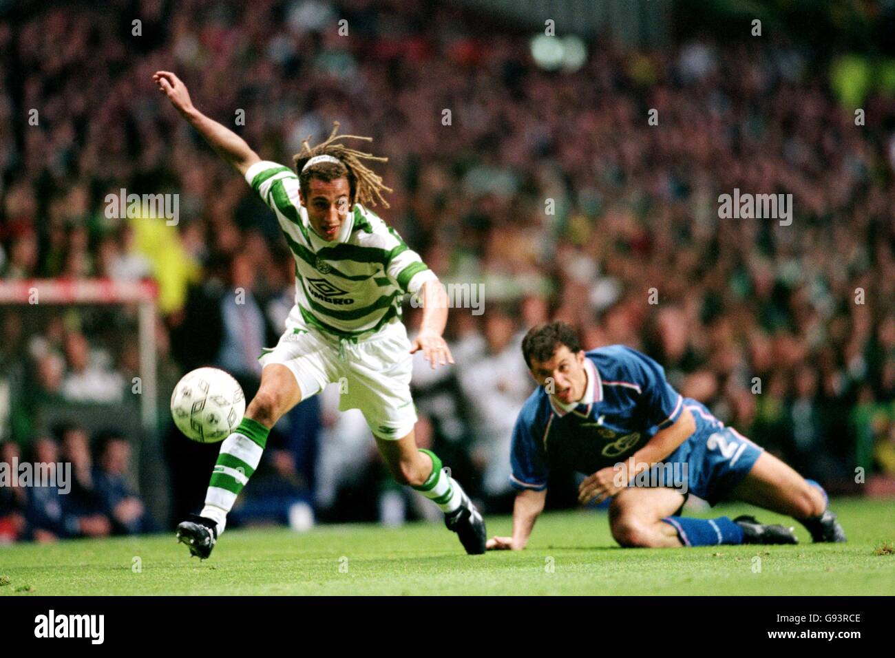 Henrik Larsson of Celtic (left) evades the challenge of Mario Tokic of ...