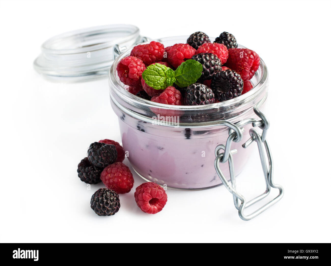 Yogurt with red and black raspberries isolated on white background ...