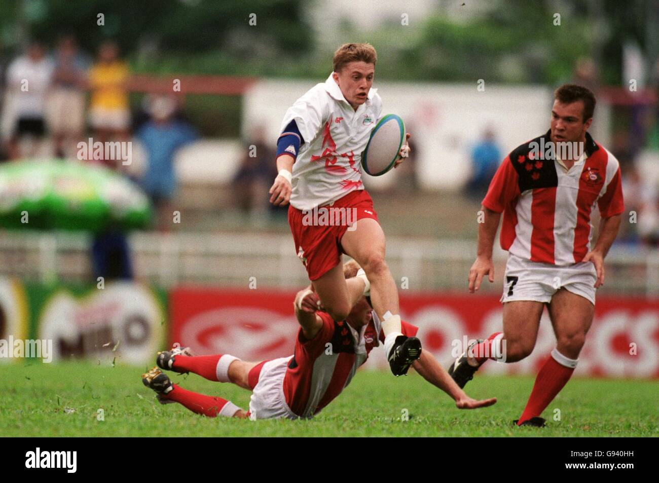 Wales's Arwel Thomas (centre) beats the tackle of Canada's Stanley ...