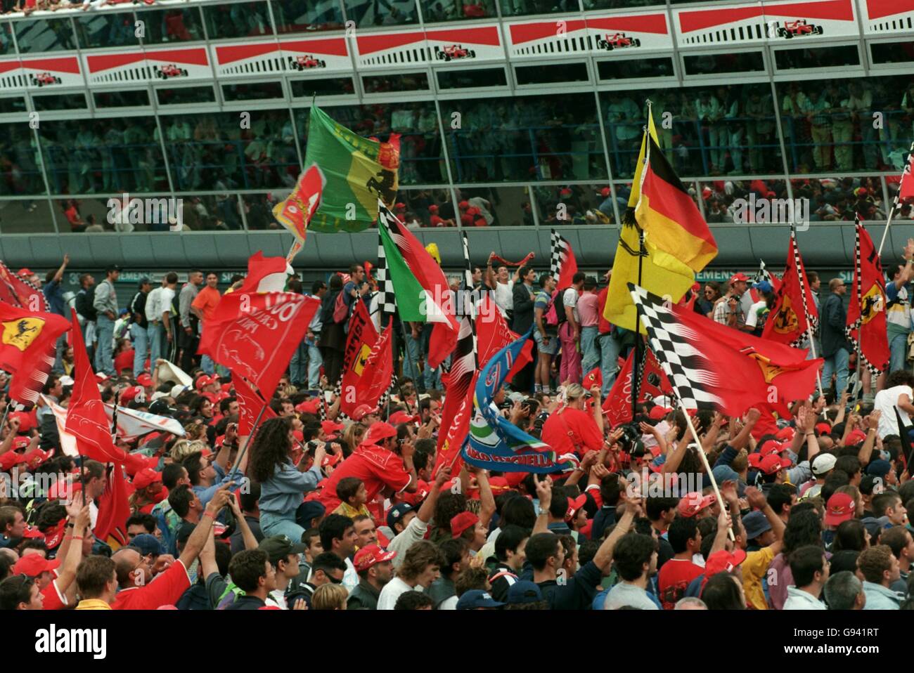 The crowd wave Ferrari flags as they strain to see the victorious ...