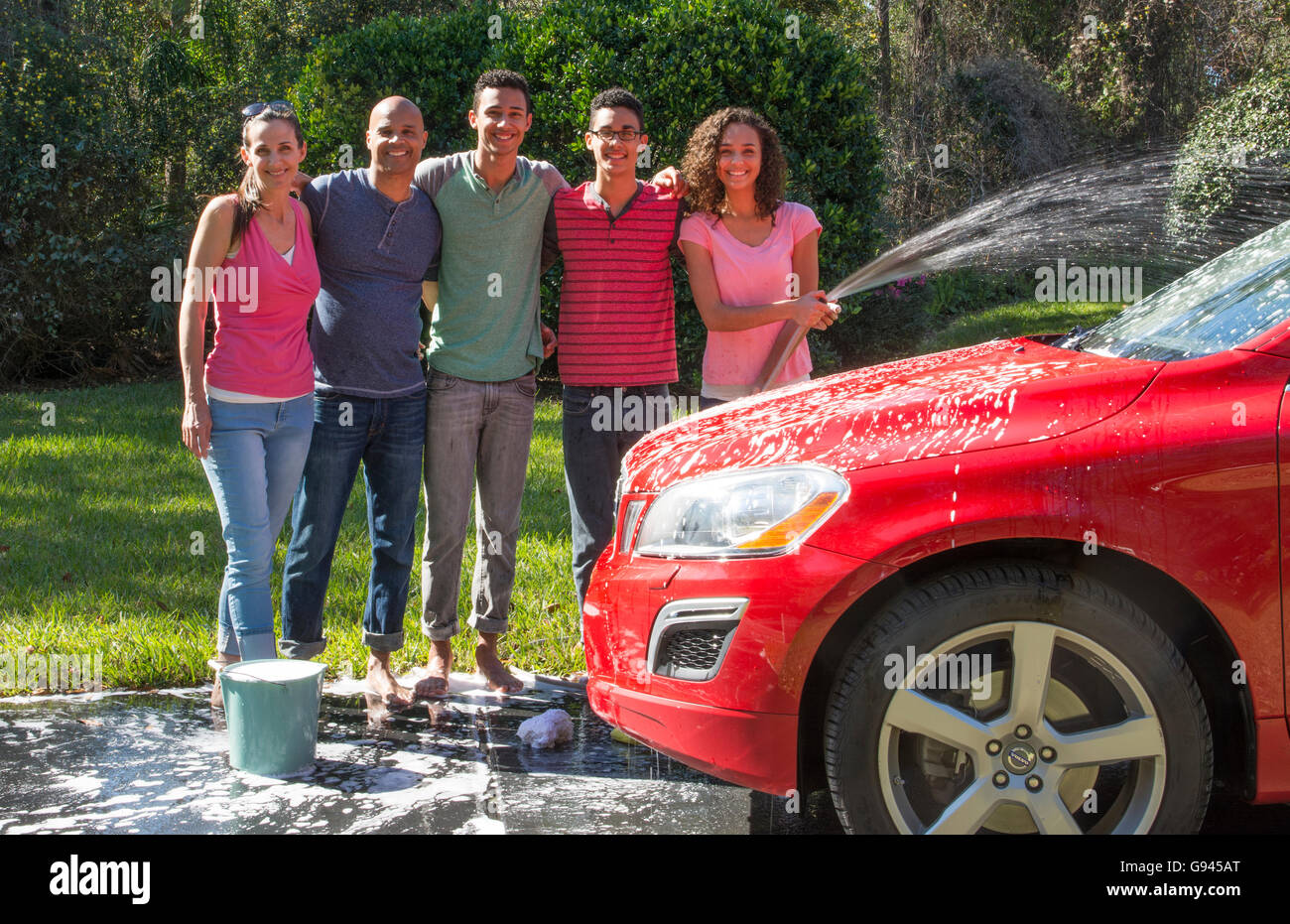 Family wash car portrait at home black Caribbean dad mom sons and ...