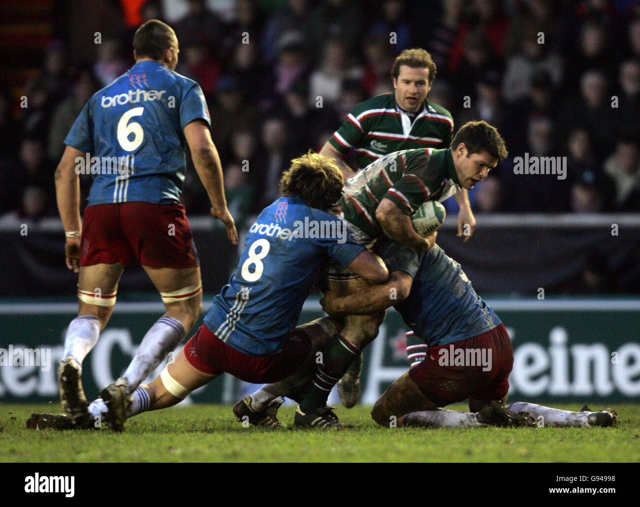 Leicester's Dan Hipkiss is tackled by Stade Francais' Shaun Sowerby and ...