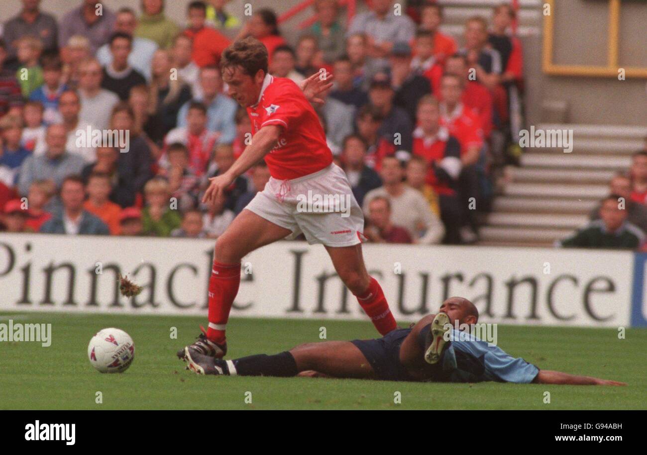 Alan Rogers of Nottingham Forest (left) brings the ball out of his ...