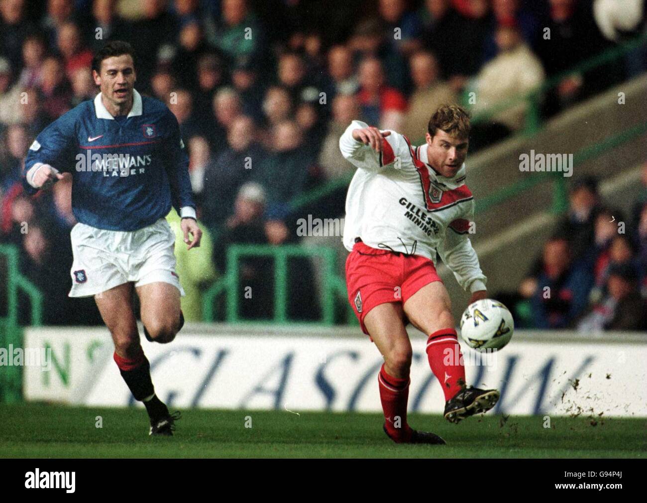 Airdie's Austin McCann crosses the ball as Rangers' Andrei Kanchelskis ...