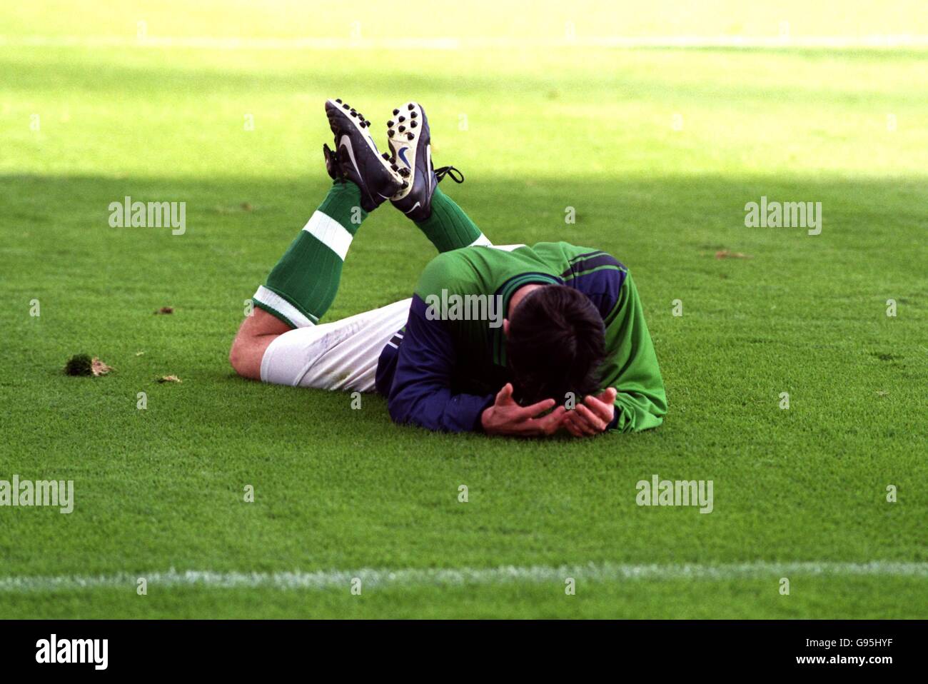 Northern Ireland's Keith Gillespie holds his head after being brought ...