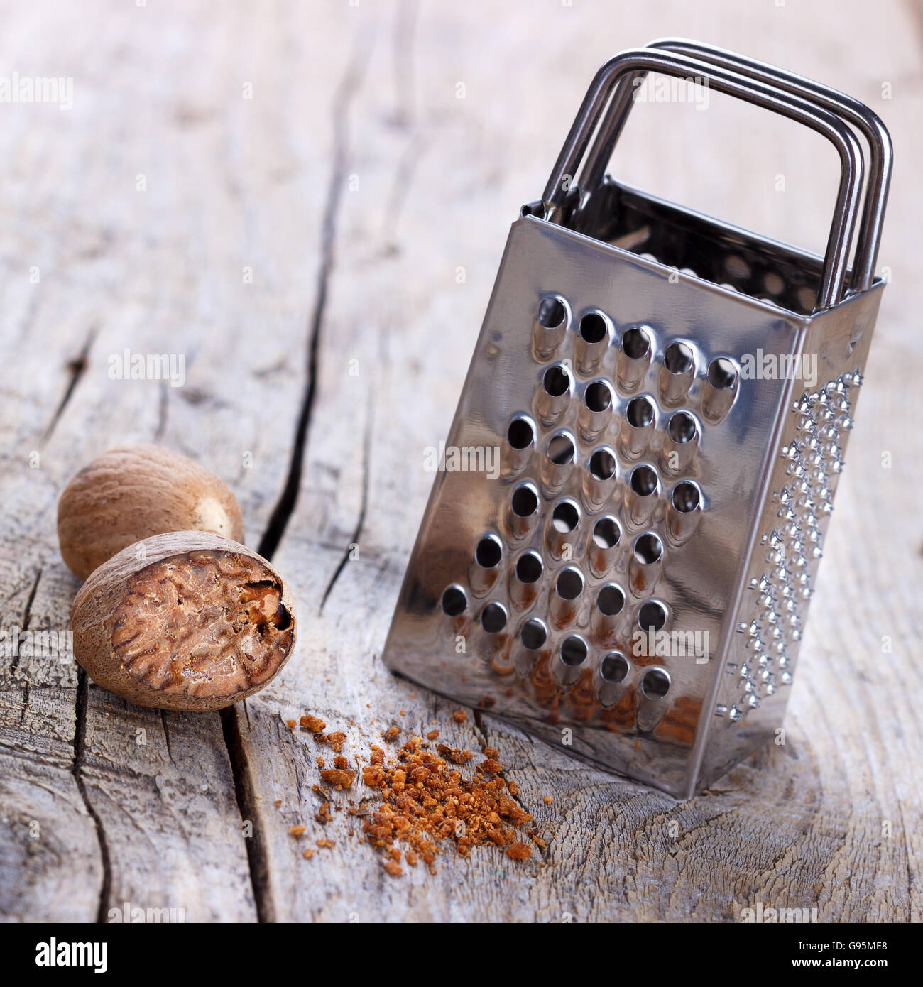 Ground nutmeg spice and grater on wooden background, closeup.Selective ...