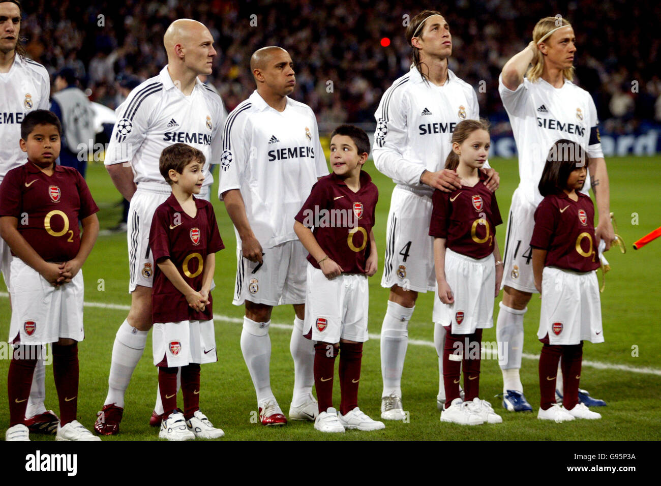 Real Madrid players line up with Arsenal mascots prior to kick off ...