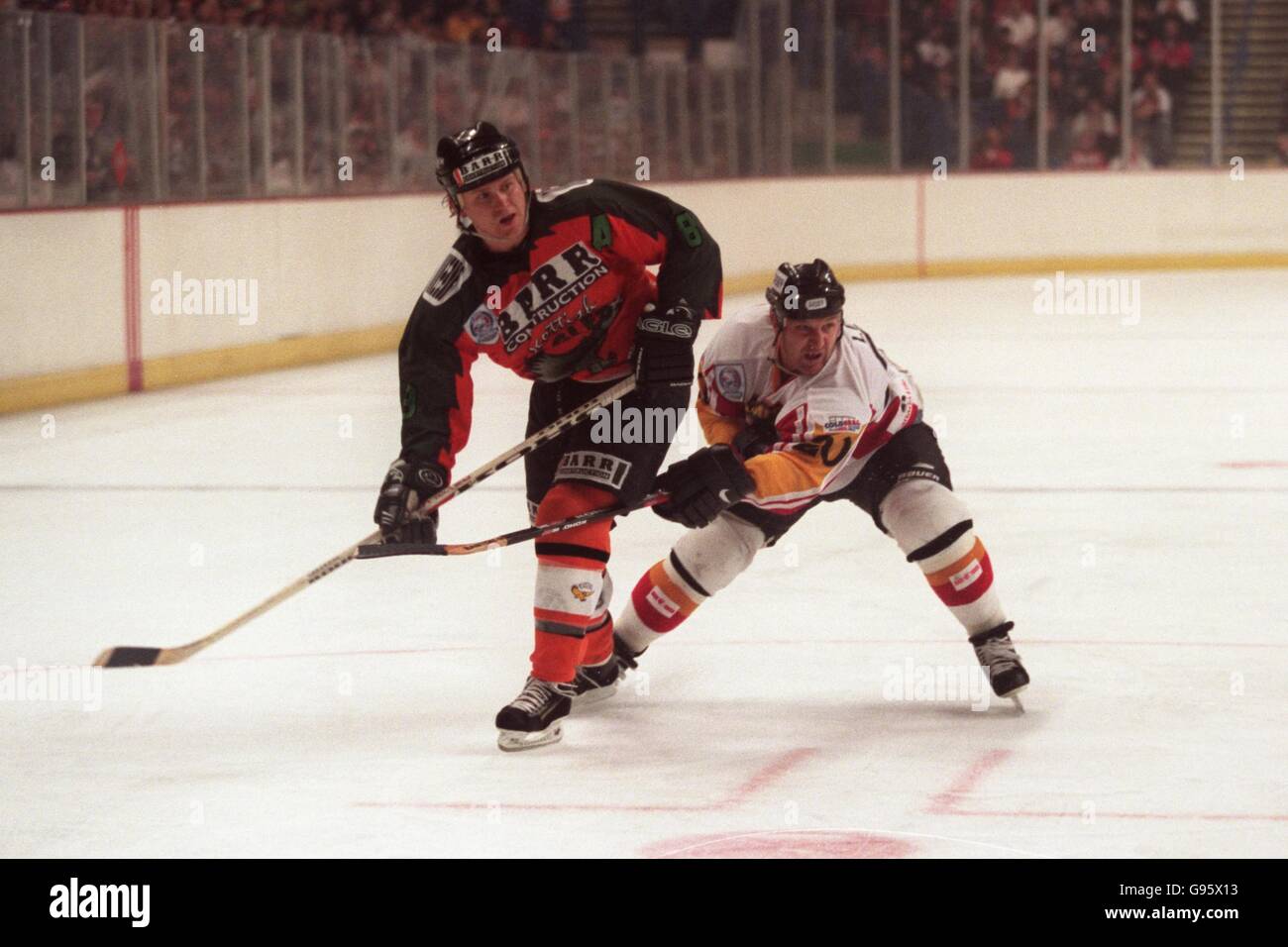 Ayr Scottish Eagles' Mark Woolf (left) shoots for goal under pressure ...