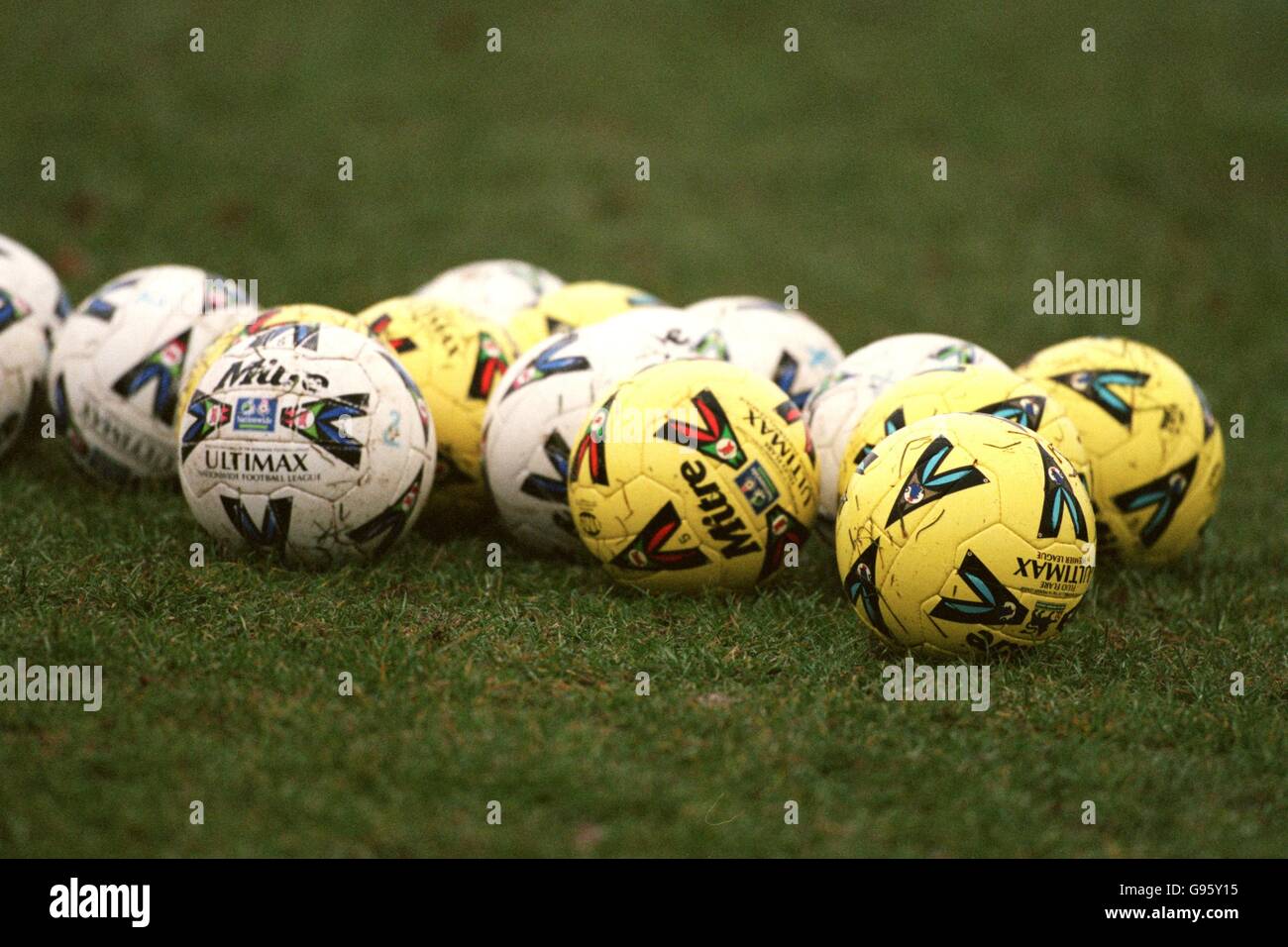A pile of white and fluorescent yellow footballs ready for training ...