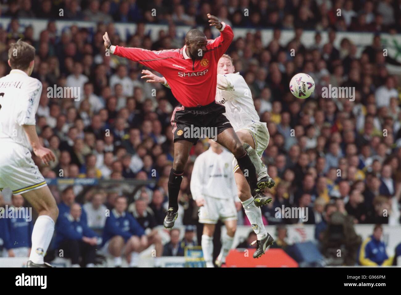 Manchester United's Andy Cole and Leeds United's David Batty jump for ...