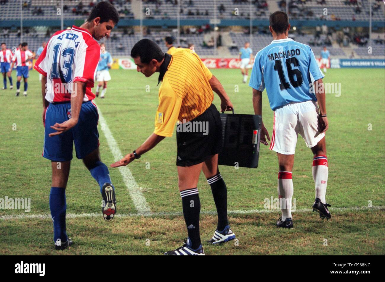 Fourth official William Mattus (centre) checks the studs of Paraguay's ...
