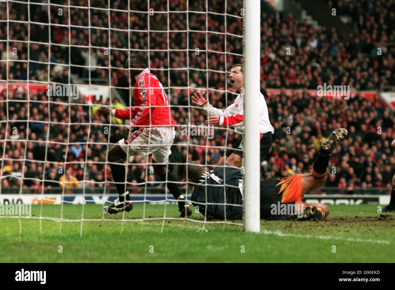Manchester United's Dwight Yorke (left) avoids Jamie Carragher and ...