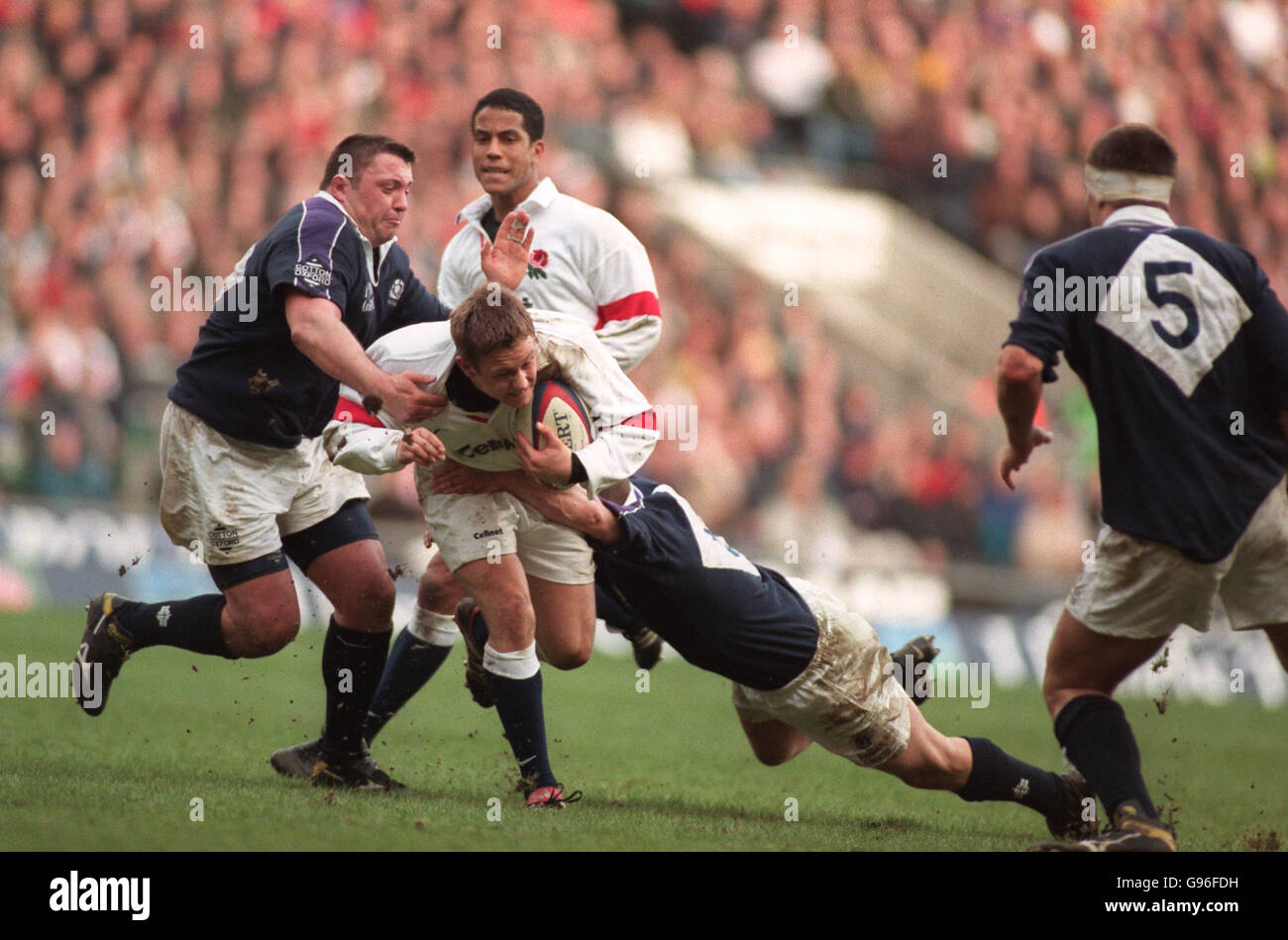 England's Jonny Wilkinson is tackled by Scotland's Paul Burnell and ...