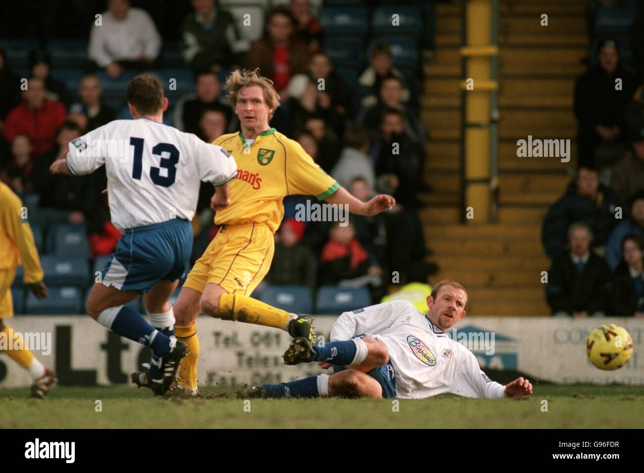 Norwich City's Craig Fleming gets the ball away despite the tackles of ...