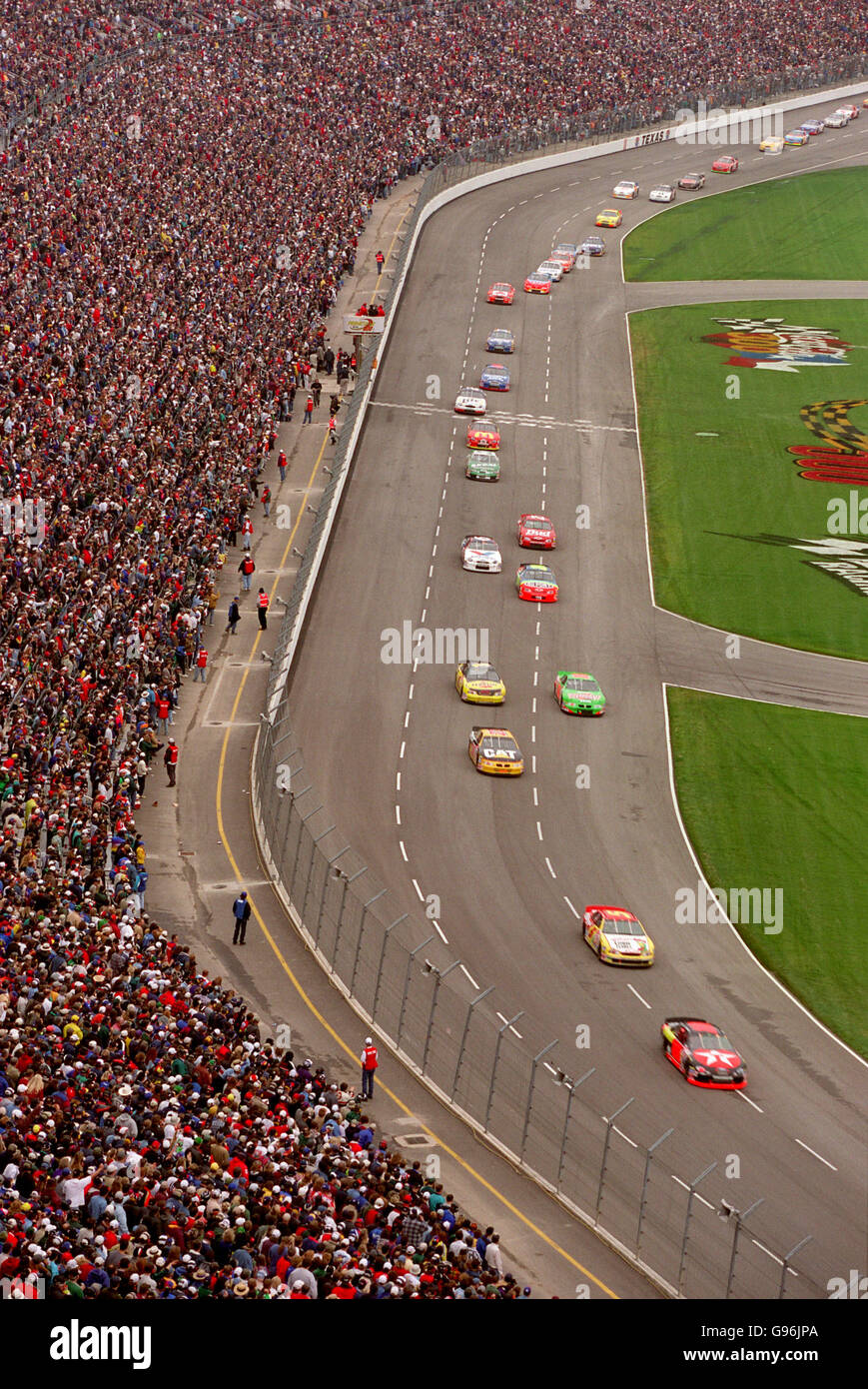 Nascars speed past the enormous grandstand during the race hi-res stock ...