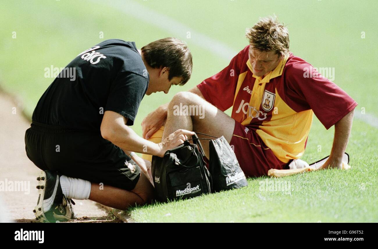 Bradford City's Lee Sharpe is given treatment before leaving the match ...