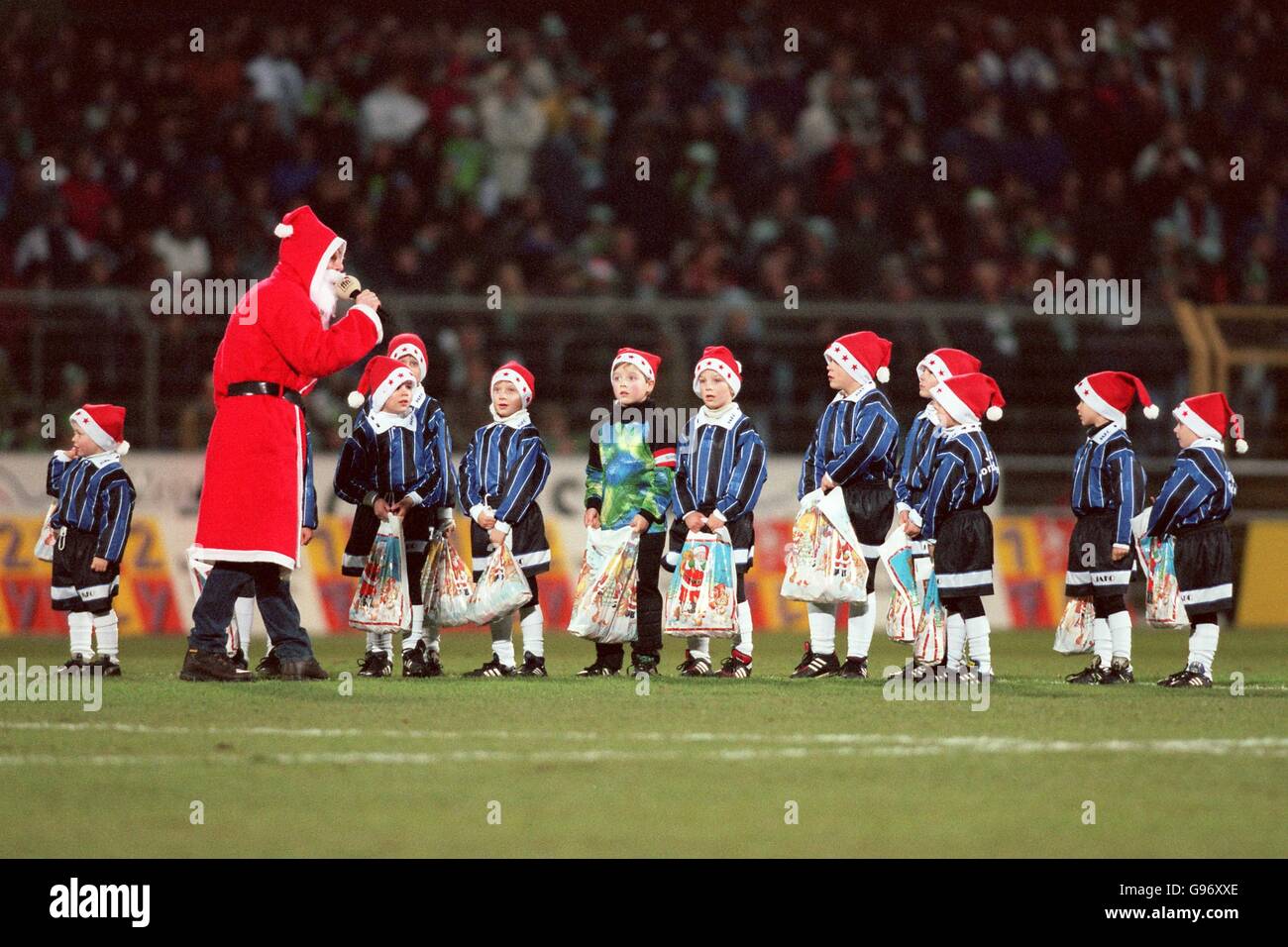 Santa claus team of footballing elves on the pitch hi-res stock ...