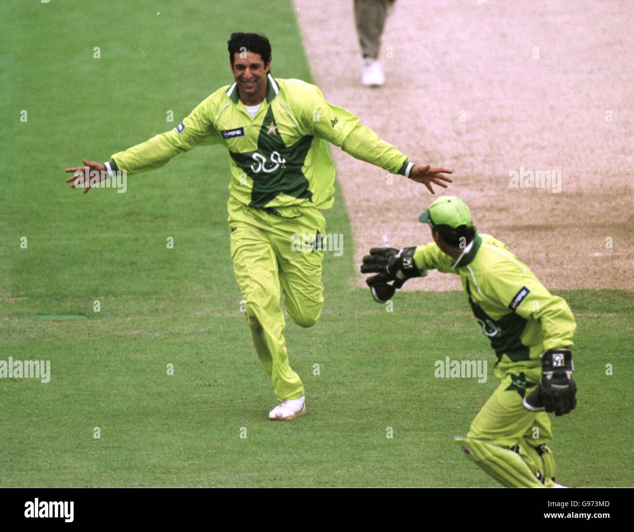 Pakistan's Wasim Akram runs off to celebrate the victory with ...