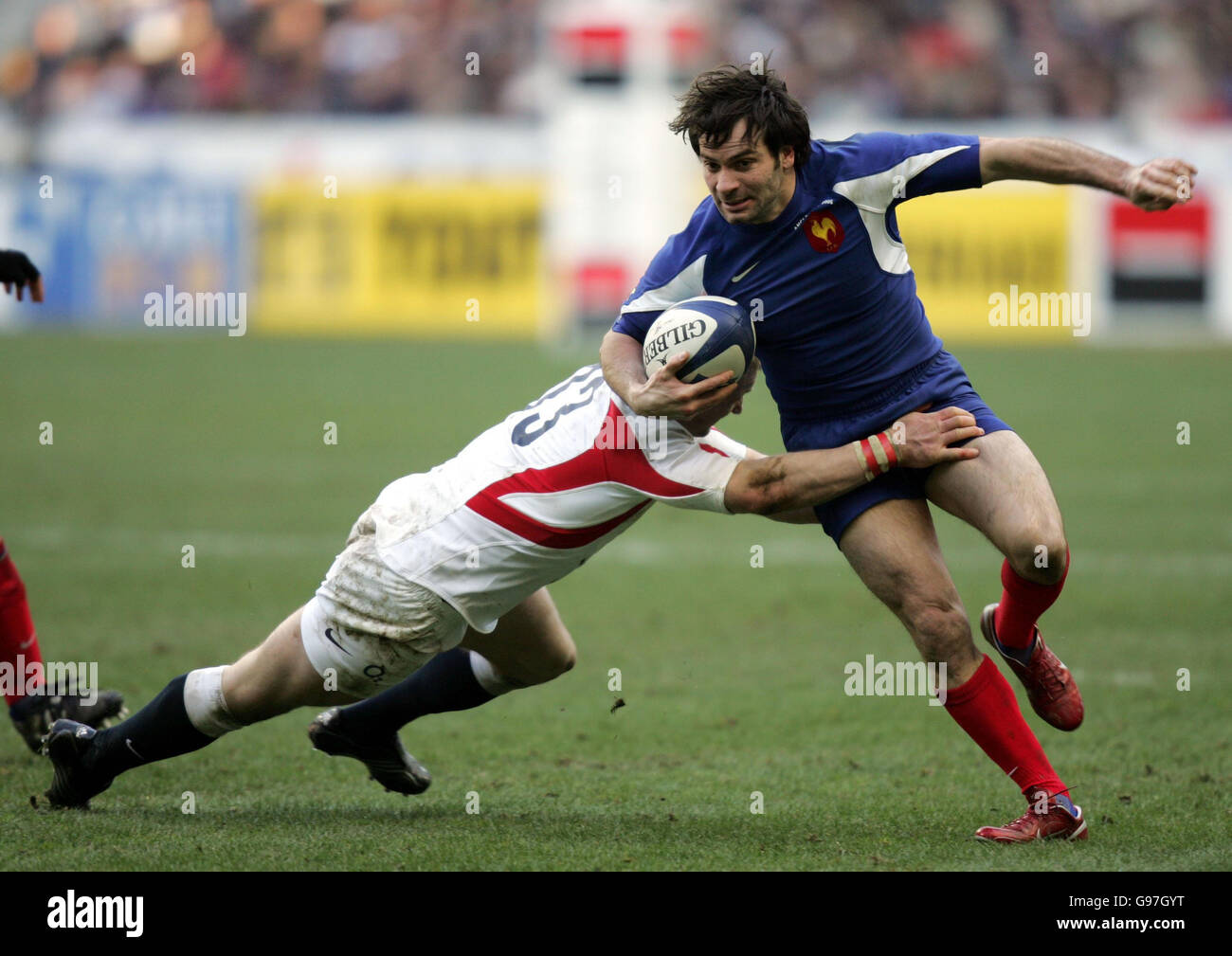 France's Christophe Dominici escapes the tackle of England's Jamie Noon ...
