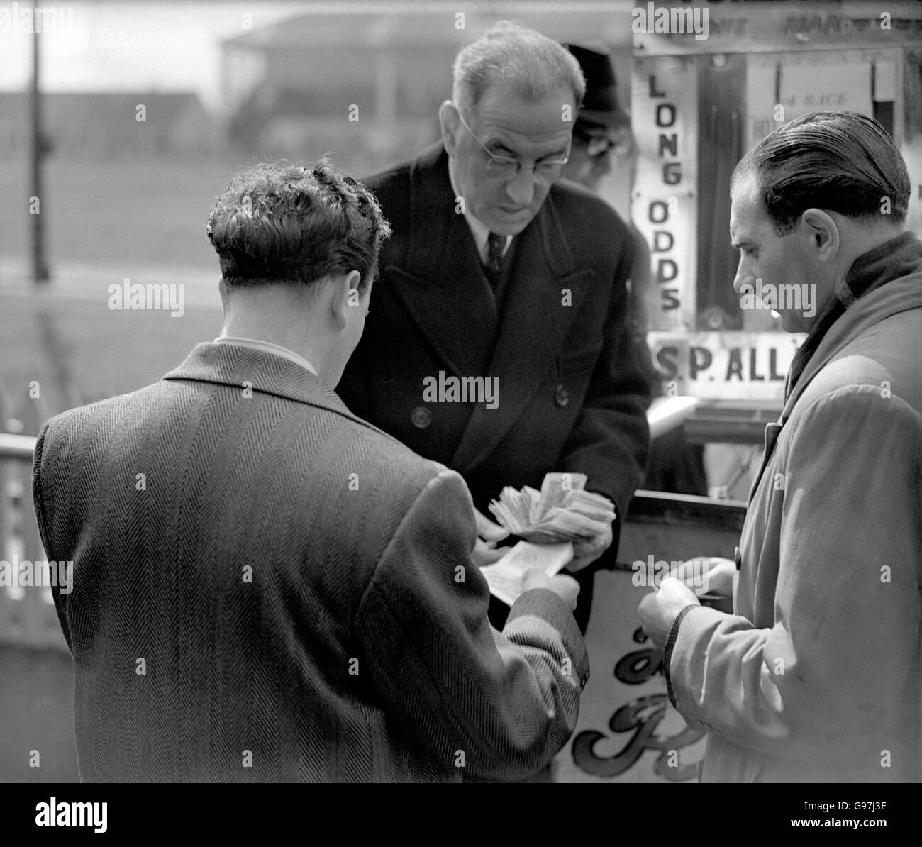 Greyhound Racing - Hackney Wick Stadium. A bookmaker pays out to a ...