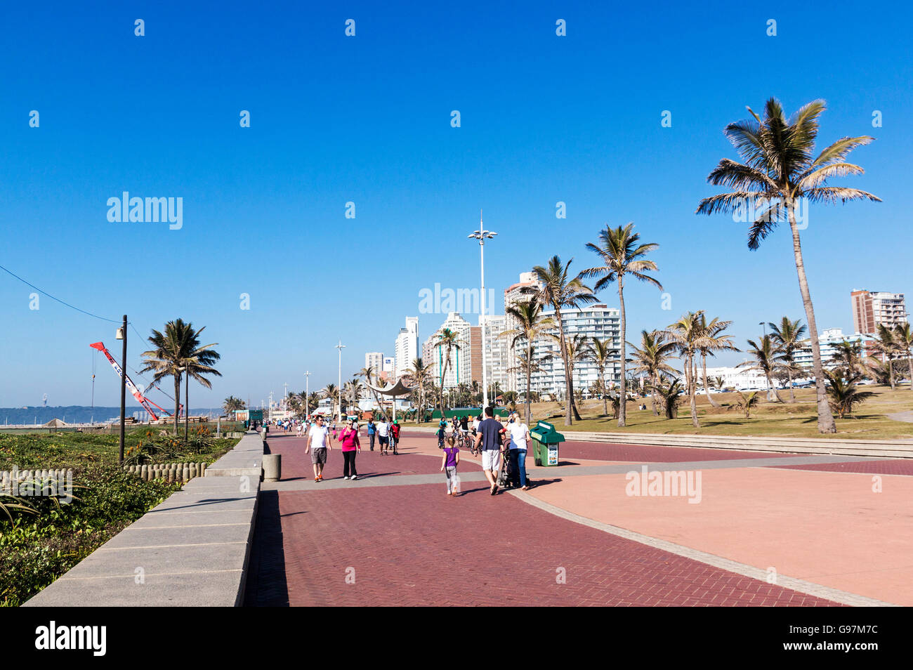 People on paved promenade on beach front against city skyline Stock ...