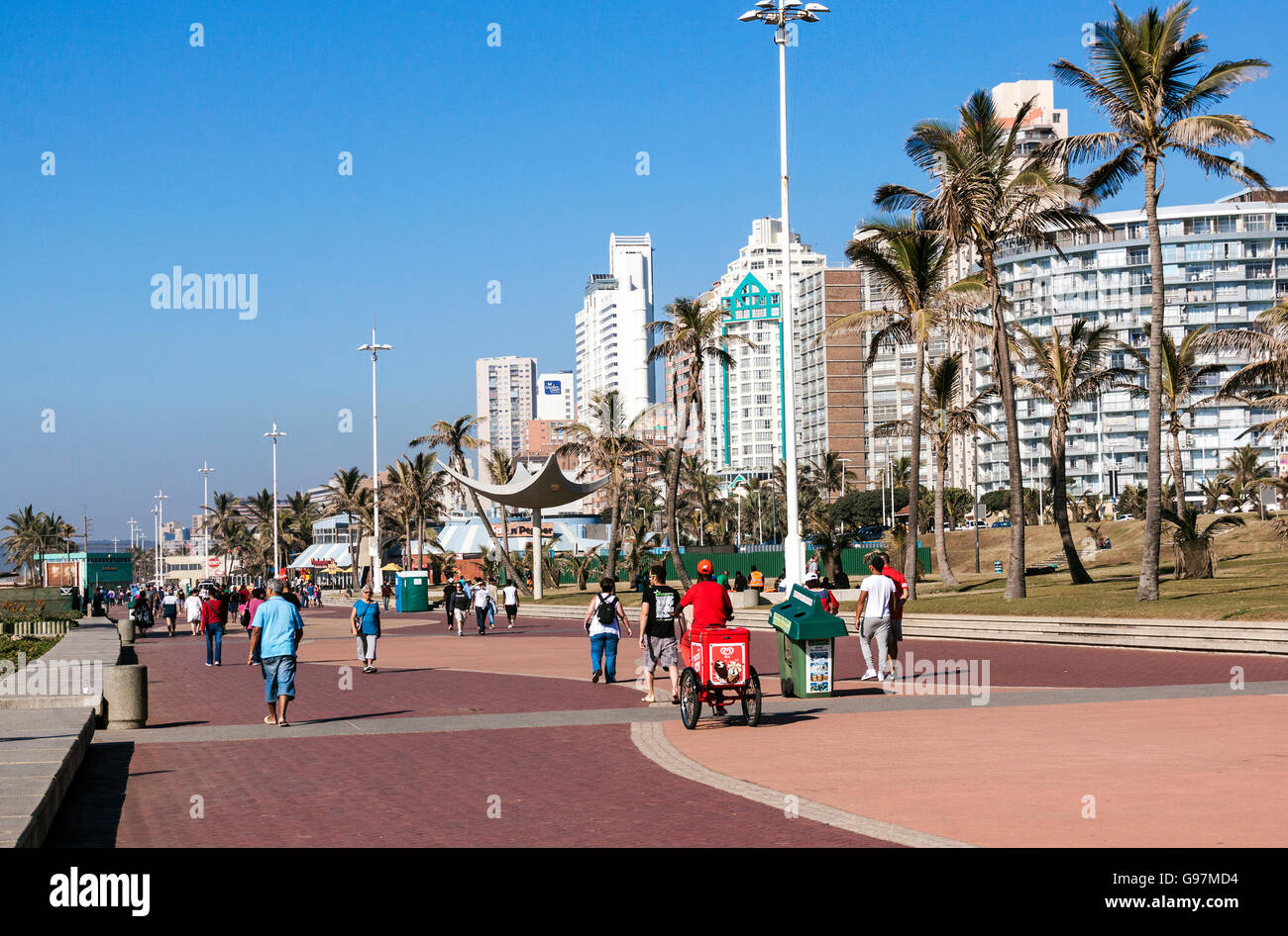 People on paved promenade on beach front against city skyline Stock ...