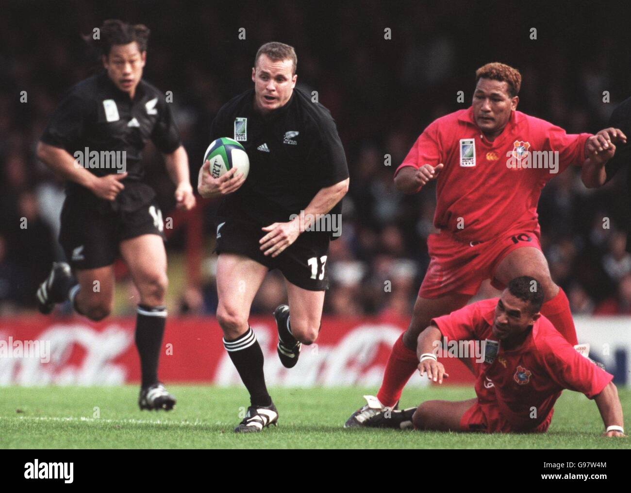New Zealand's Christian Cullen gets away from Tonga's Tevita Tiueti ...