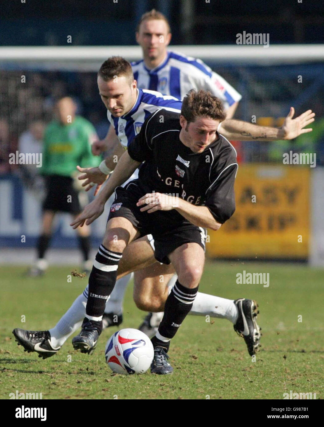 Brentford's Paul Brooker takes to ball away from Colchester's Karl ...