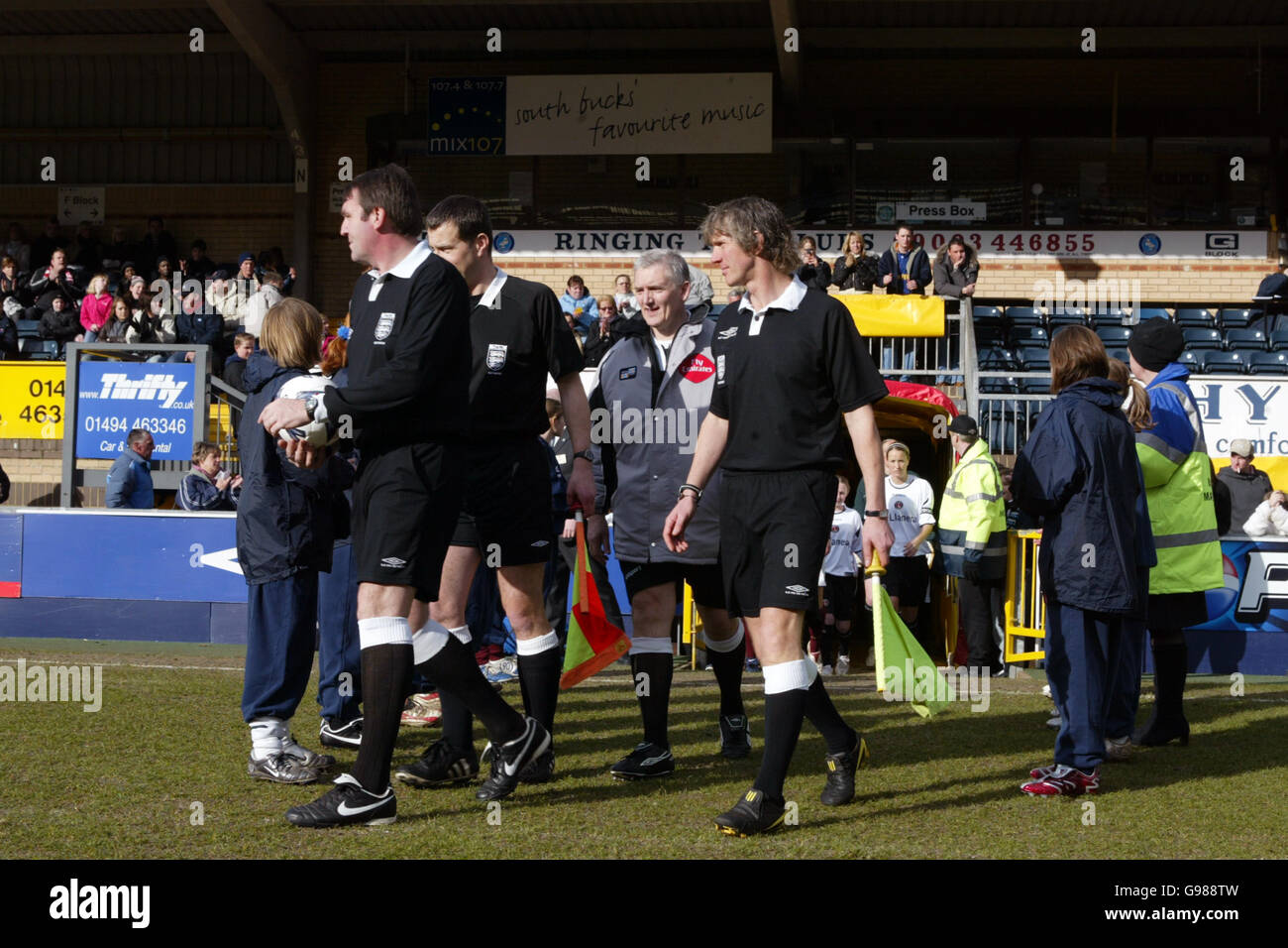 The match officials lead the teams out onto the pitch Stock Photo - Alamy