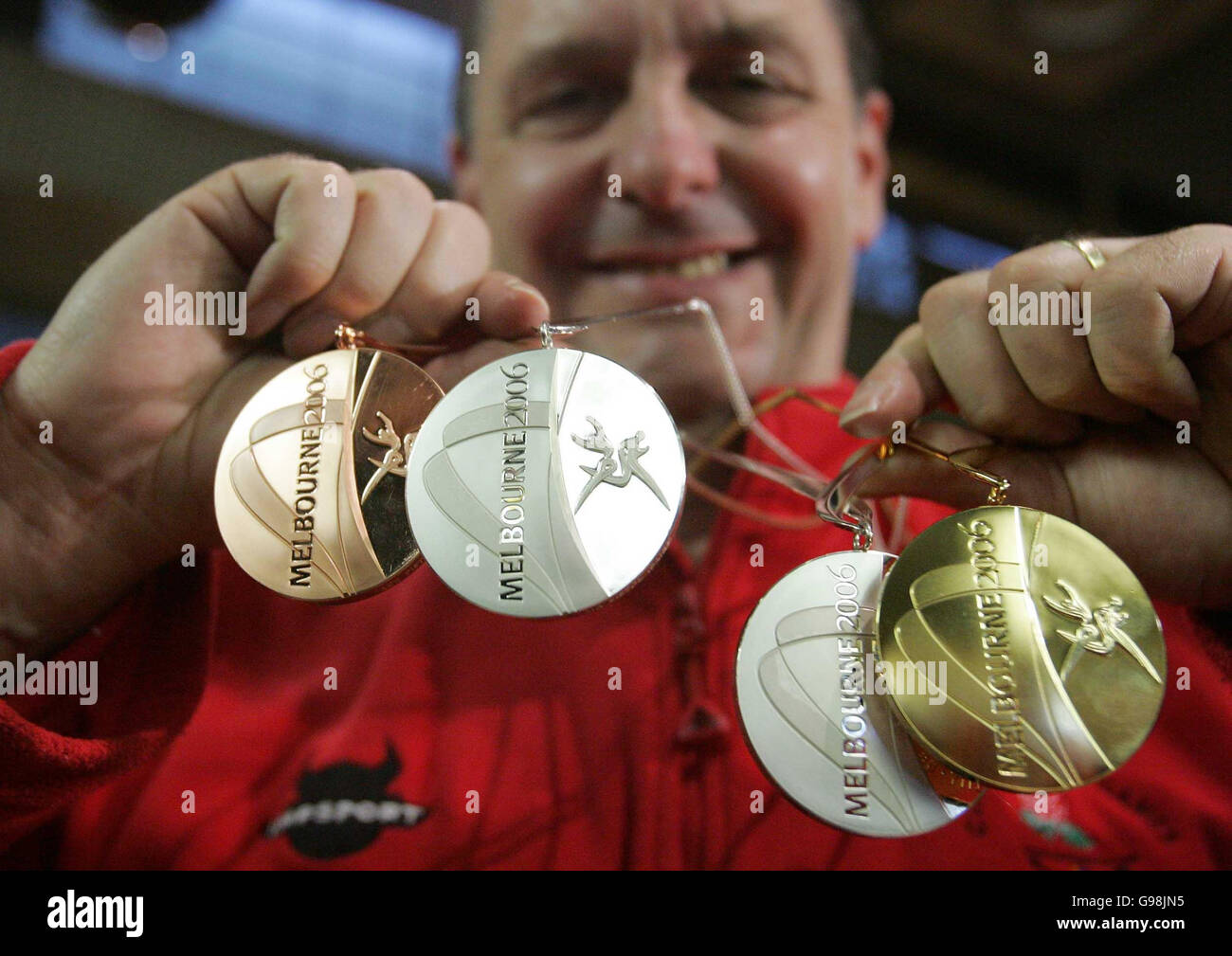 England's Mike Gault shows off his medals after arriving at Heathrow ...