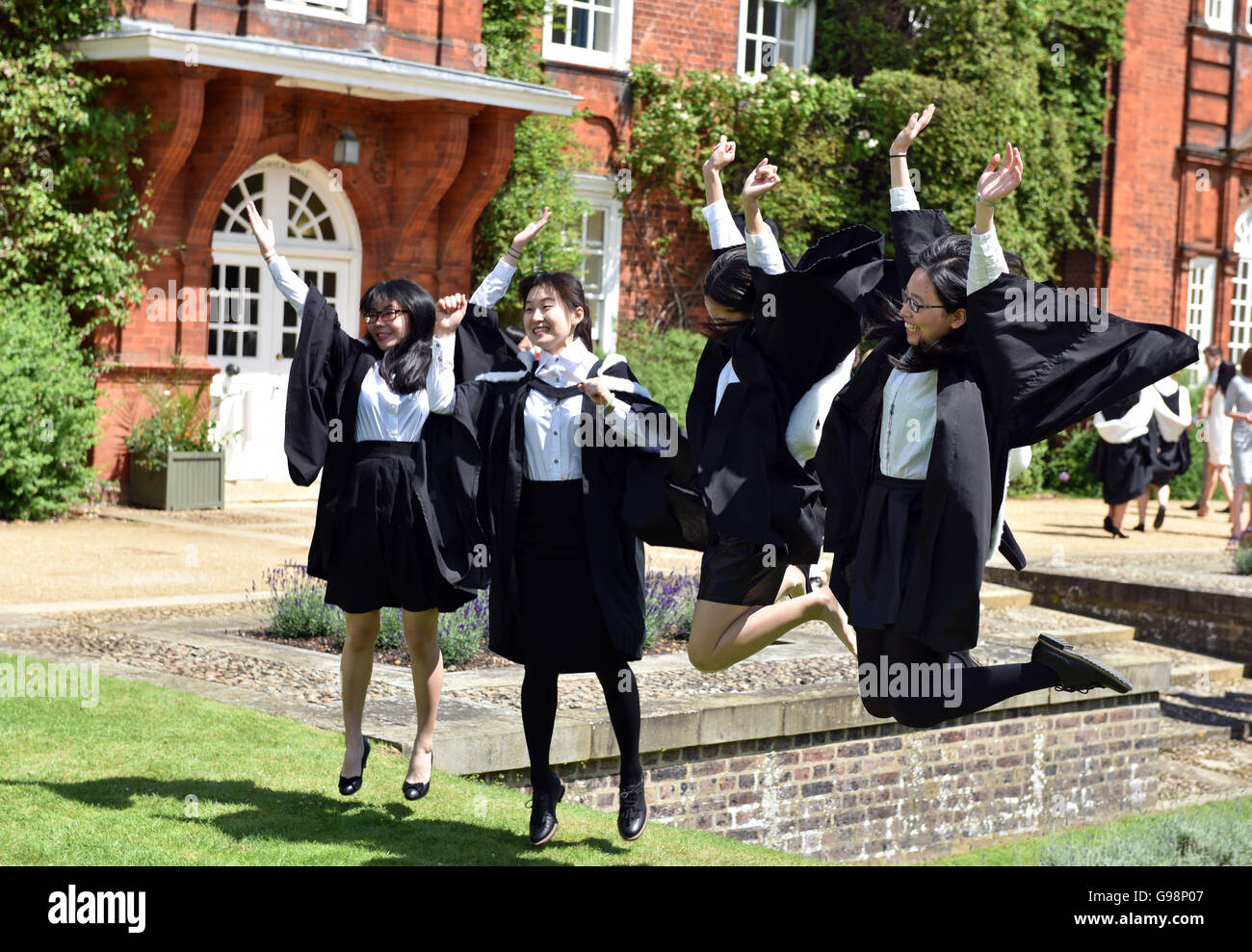 Smiling students jump into the air to celebrate graduation at Cambridge ...