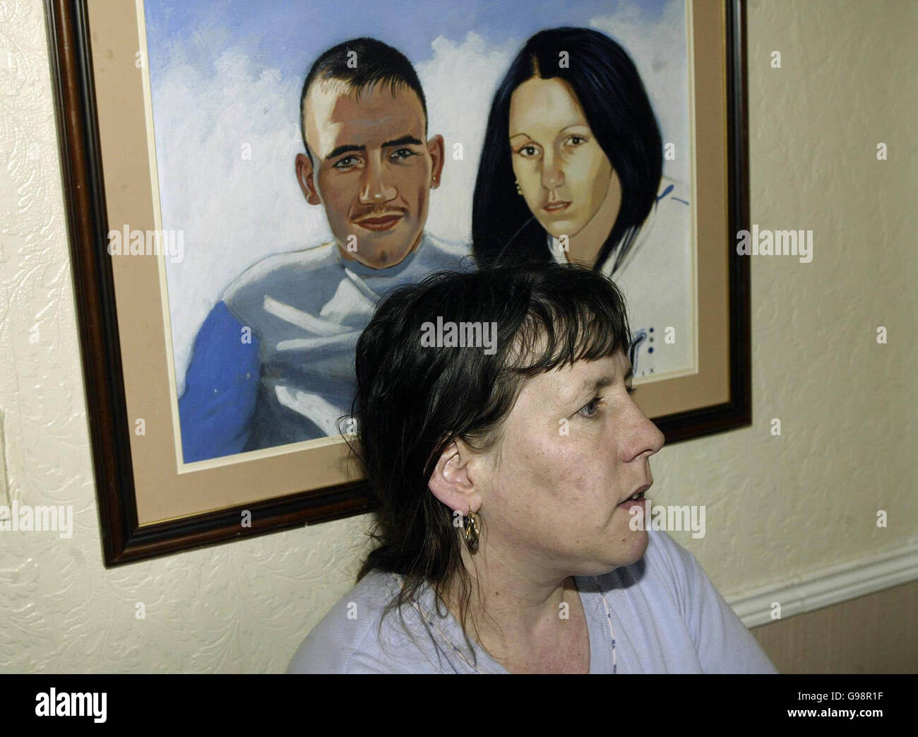 Mary McComb whose son Wayne was shot in the leg sits beside a painting ...
