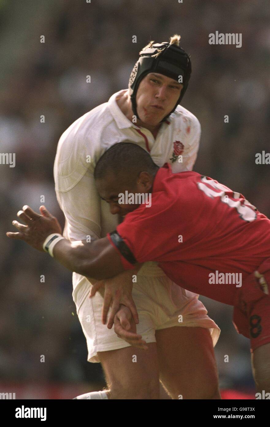 England's Garath Archer (left) is crunched by Tonga's Semi Taupeaafe ...